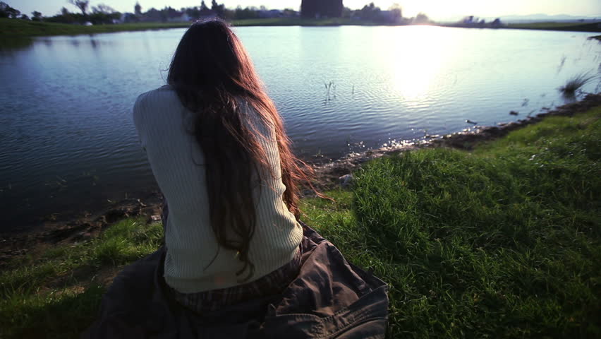 Rear View Long Haired Woman Sitting Near River And Looking At Water ...