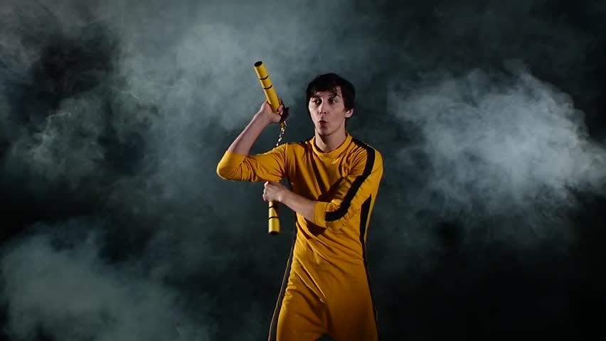 The Man In Yellow Suit Practicing Kung Fu. Master Holding Nunchuck ...