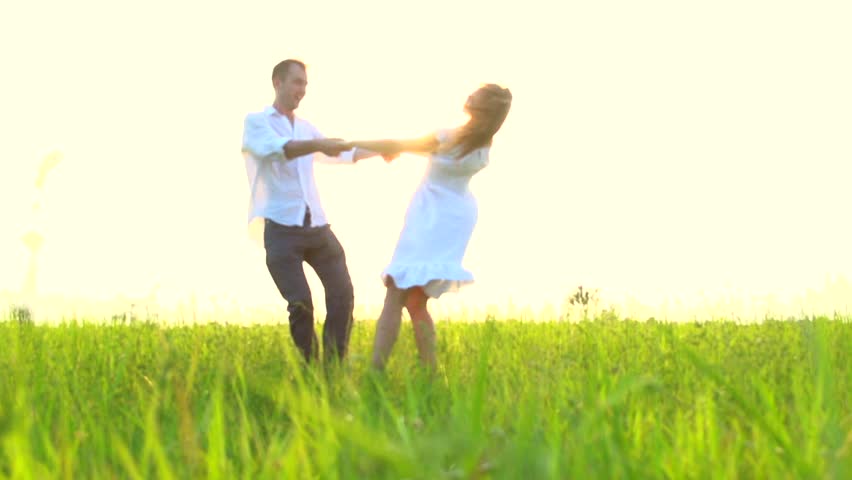 Happy Young Couple Holding Hands Run Through A Wide Field, Having Fun ...