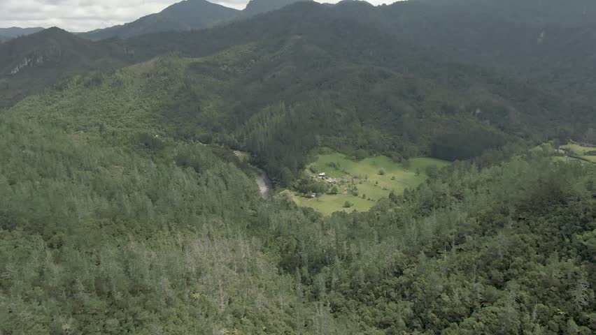 Landscape with houses, hills, and mountains in the distance image ...