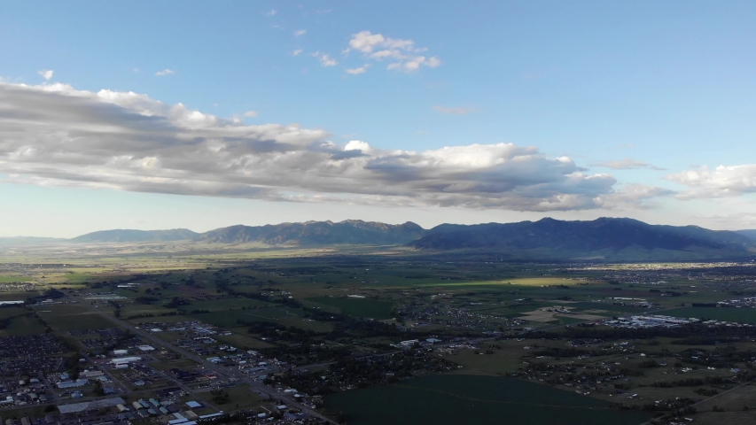 Clouds and farm landscape with town and mountains in Montana image ...