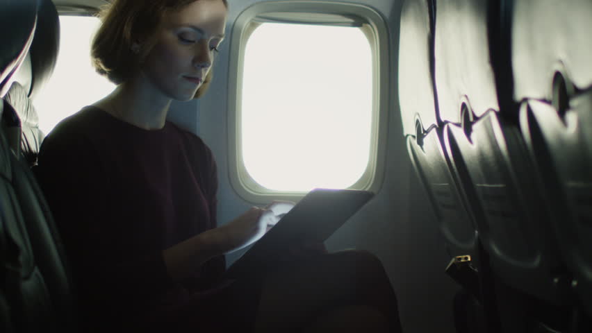 Young Woman Is Using A Smartphone Inside An Airplane Next To A Window ...