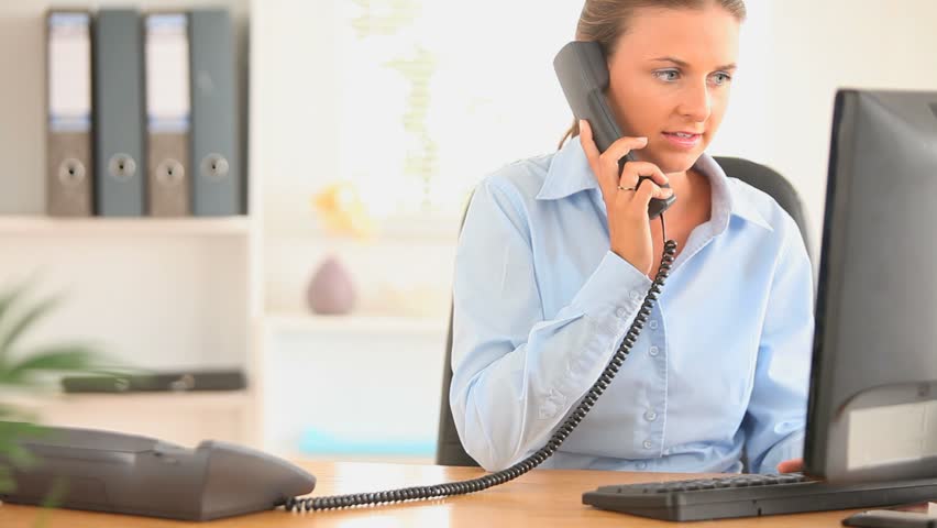 Female Office Worker Answering The Phone In Her Office Stock Footage ...