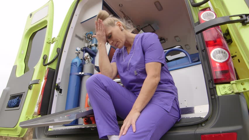 Emergency Medical Service Upset Tired Paramedic Sitting In Front Of ...