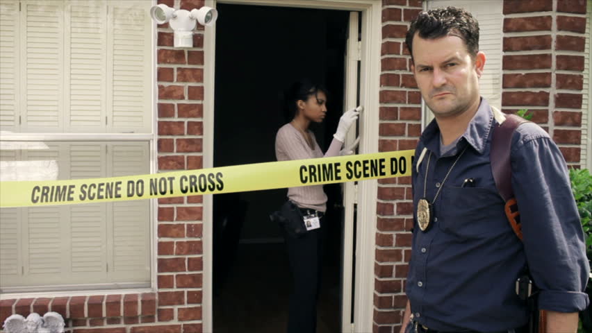 A Detective Standing In Front Of A Yellow Crime Scene Tape Turns From A ...