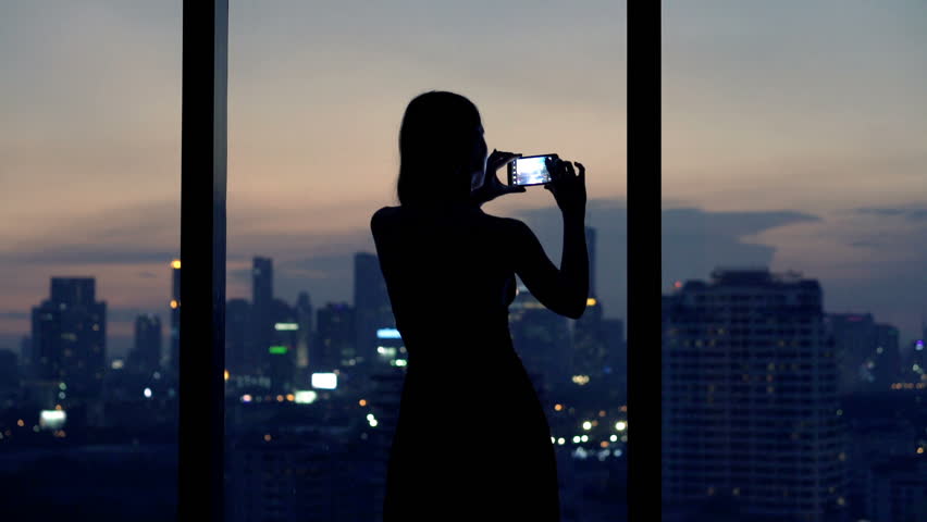 woman-looking-back-at-camera-holding-a-smartphone image - Free stock ...