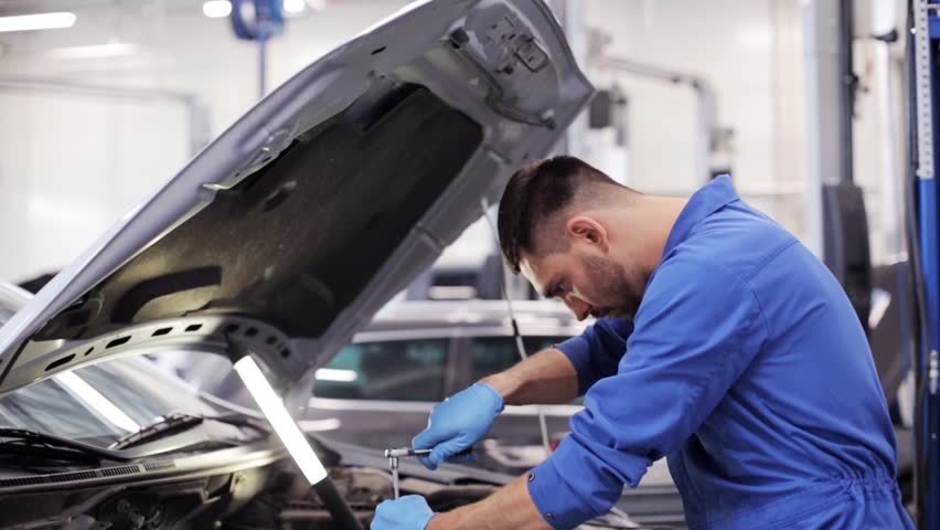 Male Tutor Instructing Female College Student In Car Mechanics Class As ...