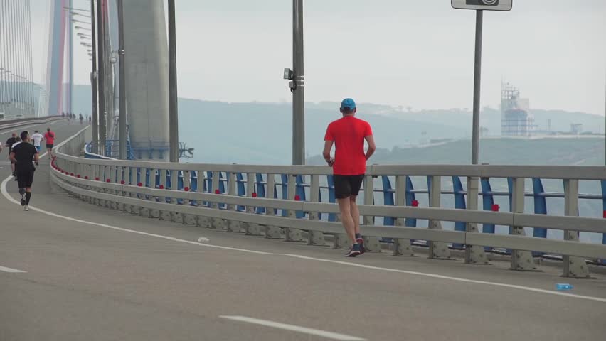 Athletes On Marathon Race Running On A Bridge. Slow Motion Stock ...
