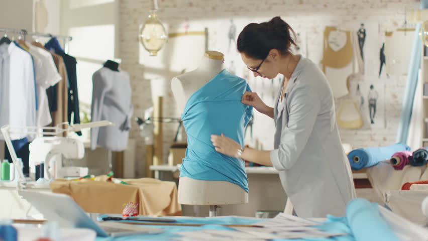 Stock Video Clip of Beautiful Female Fashion Designer Adjusting Fabrics ...