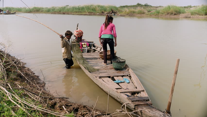 Clammer Digging For Clams Into The River-bottom By The Riverside And ...