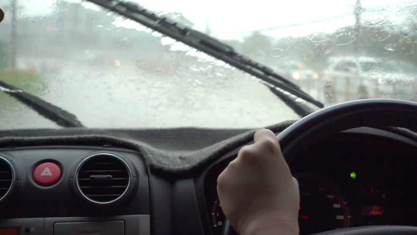 Stock Video Clip of Young woman driving the car in rainy | Shutterstock