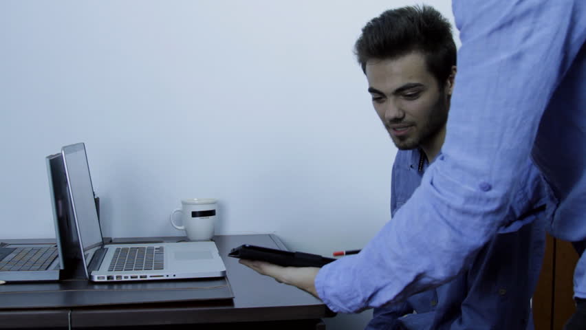Young, Handsome Man Sitting Behind The Desk And In Using Computer, Then ...