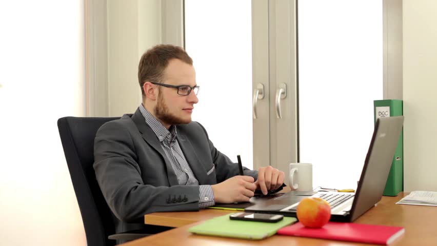 Young, Handsome Man Sitting Behind The Desk And In Using Computer, Then ...